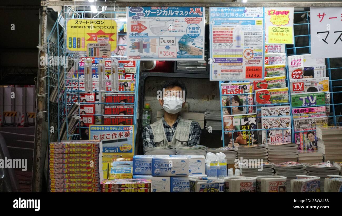 Tokyo, Japan - May 2020 : A man sitting inside his tiny newspaper shop ...