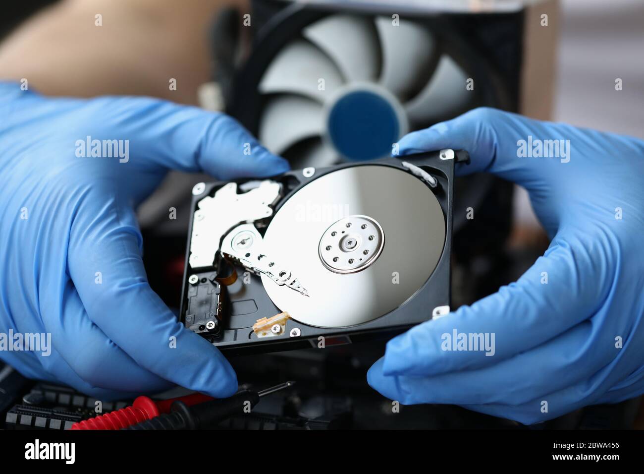 Gloved hands holding computer hard drive device Stock Photo - Alamy