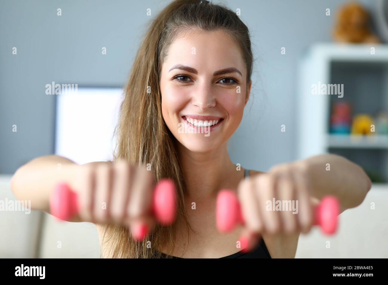 Happy girl doing exercises with dumbbells at home Stock Photo - Alamy