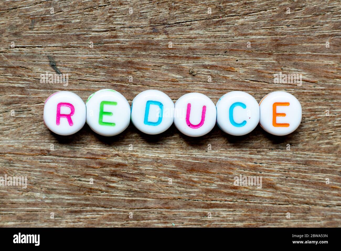 White bead with color letter in word reduce, on wood background Stock ...