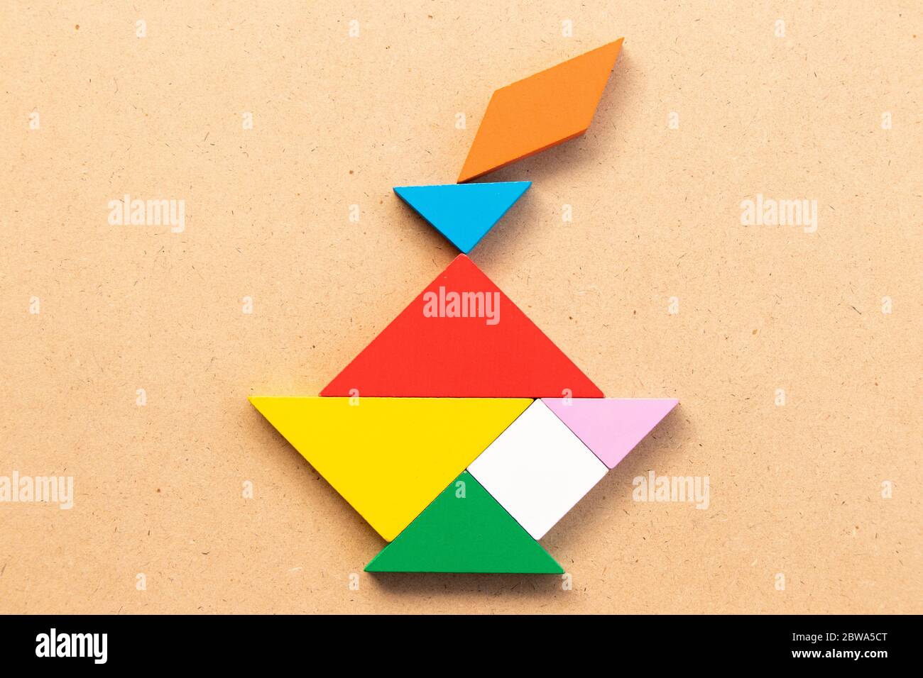 Color tangram puzzle in candleshape on wood bacground Stock Photo - Alamy