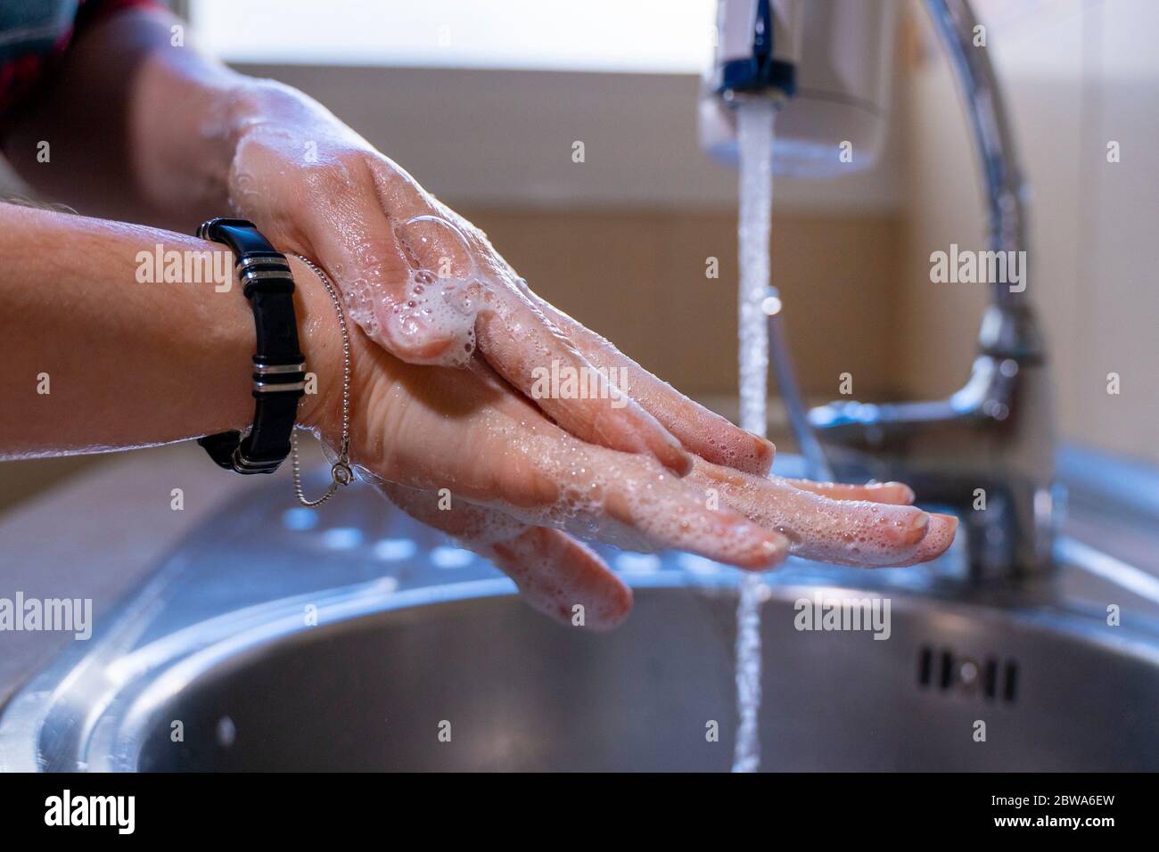 Washing hands properly with soap. Hygiene concept. Rubbing back of hand ...