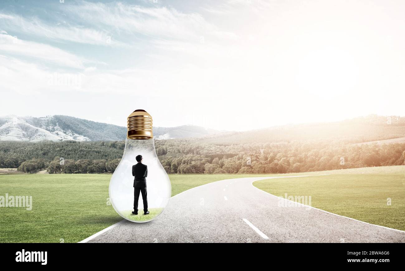 Businessman inside light bulb Stock Photo - Alamy