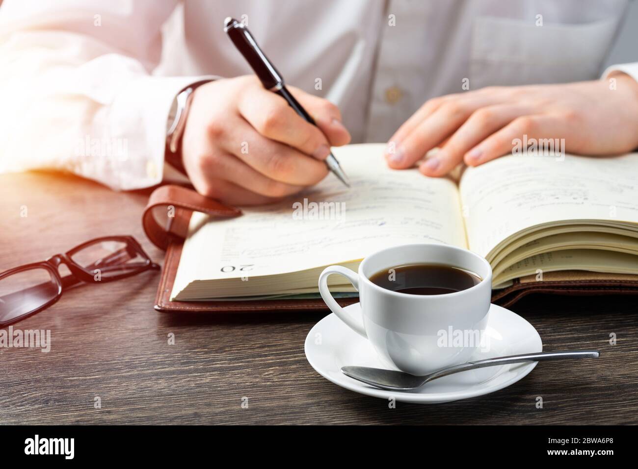 Man making notes with pen in notebook Stock Photo - Alamy