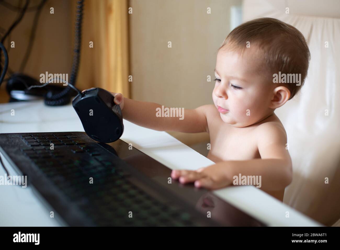 cute little baby sitting on an office chair and before the black ...