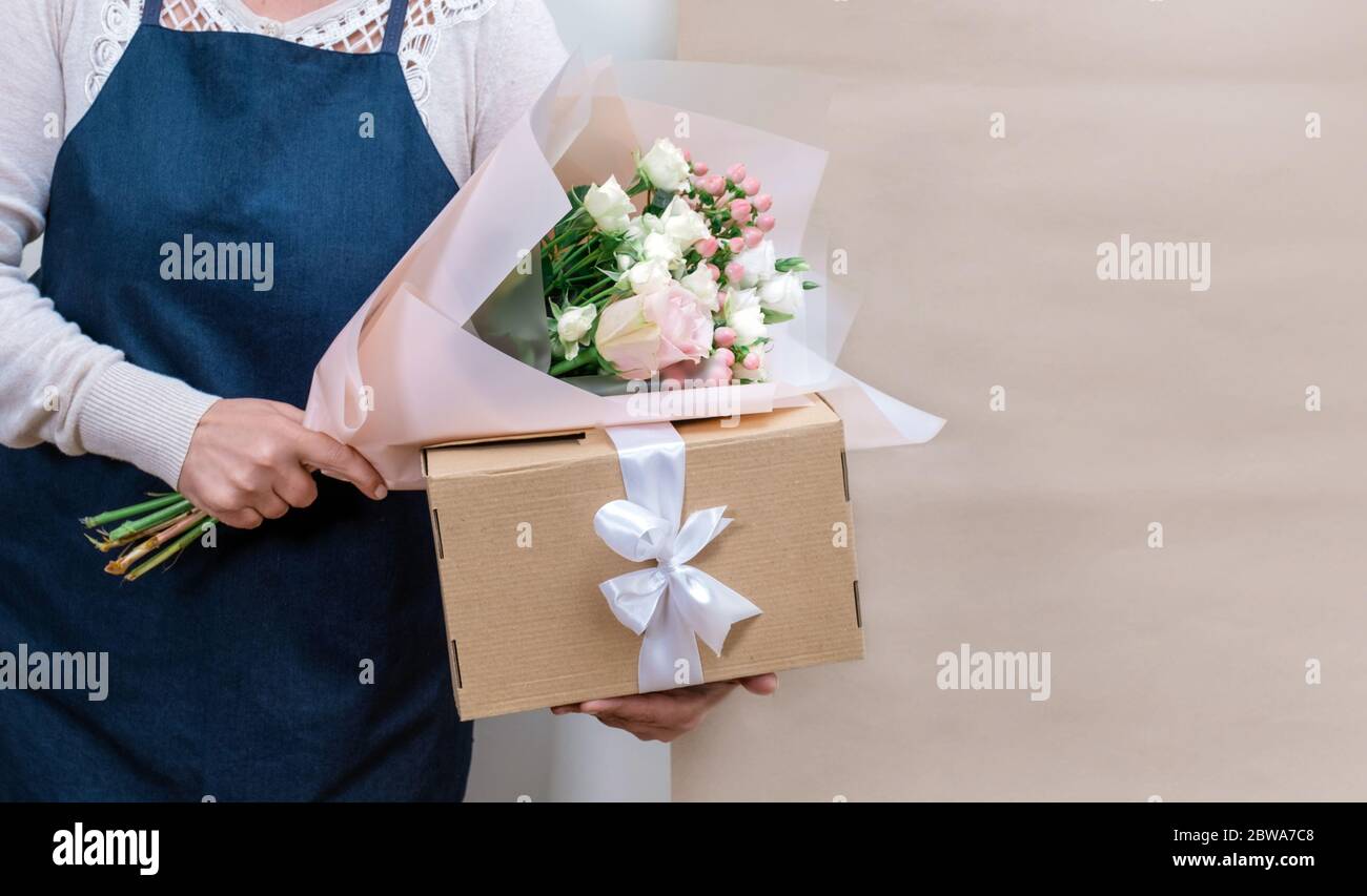 Female Worker of Delivery Service in Uniform Packing Flowers in paper ...