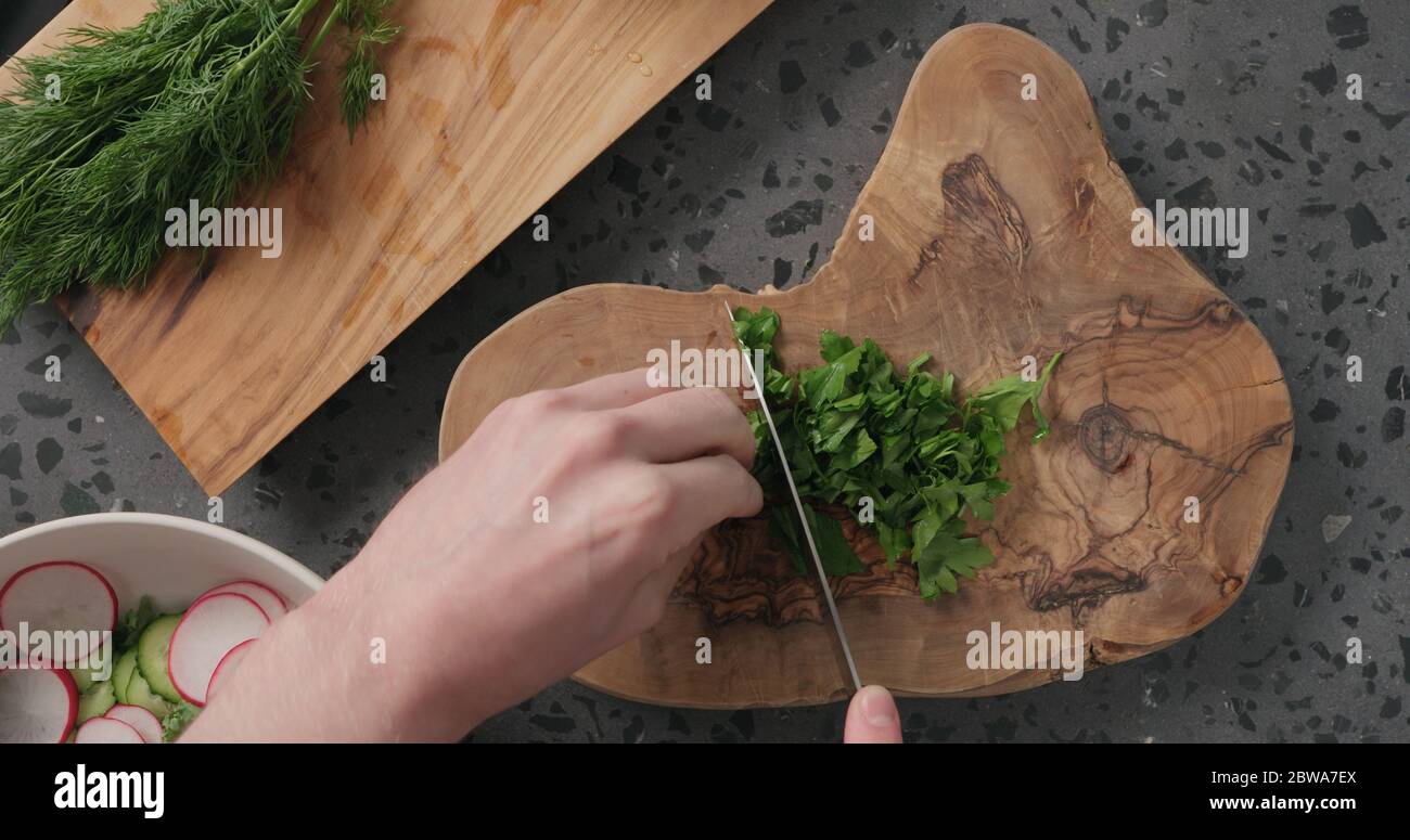 Top view man hands chop fresh parsley on concrete countertop Stock ...