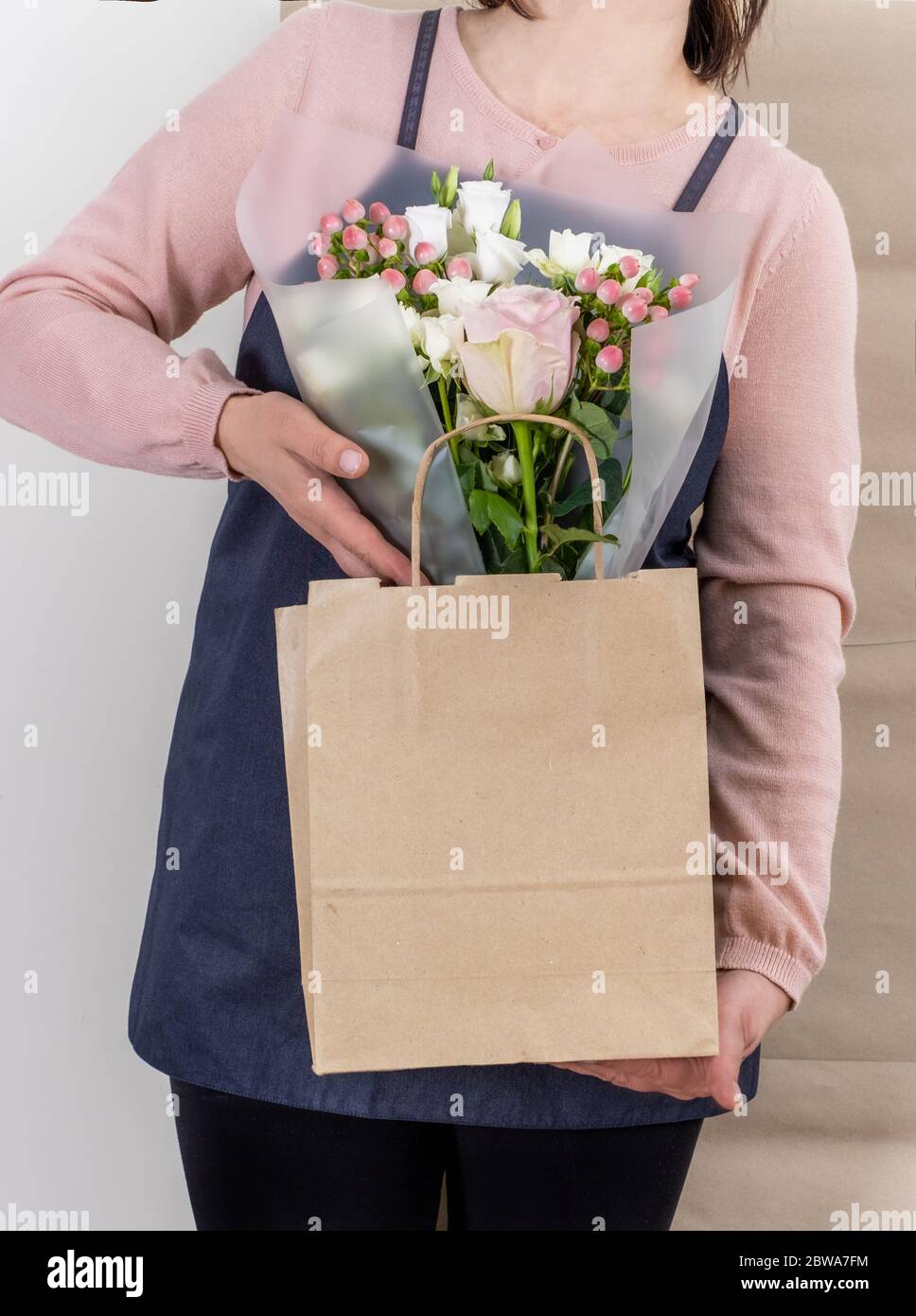 Female Worker of Delivery Service in Uniform Packing Flowers in paper ...