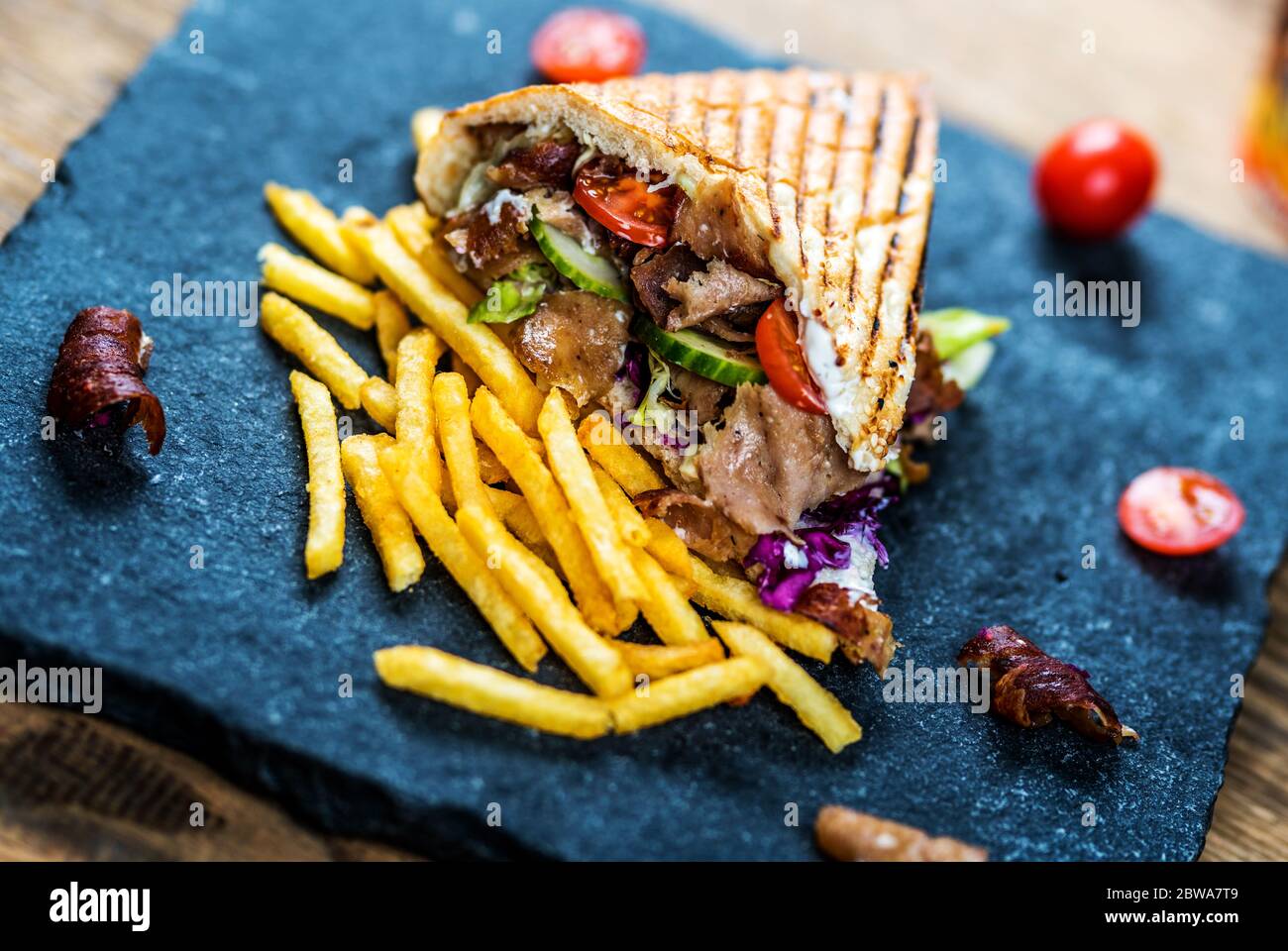 Doner kebab with vegetables and french fries on wood table Stock Photo ...