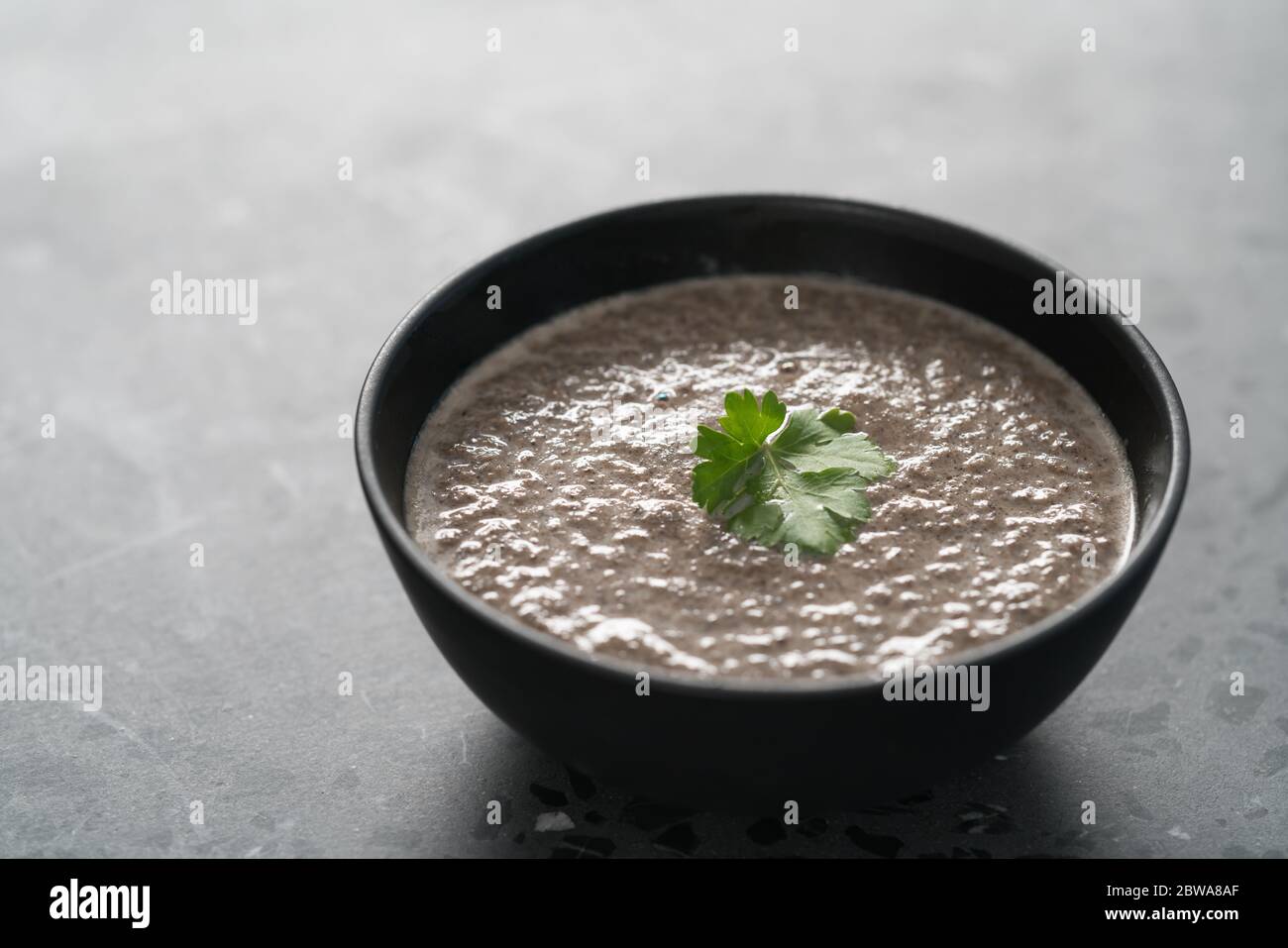 Mushroom soup puree in black bowl on concrete background Stock Photo ...