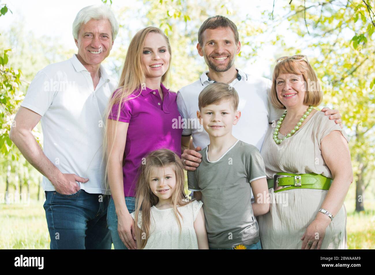 Multigeneration family portrait outdoors. Happy parents with two ...