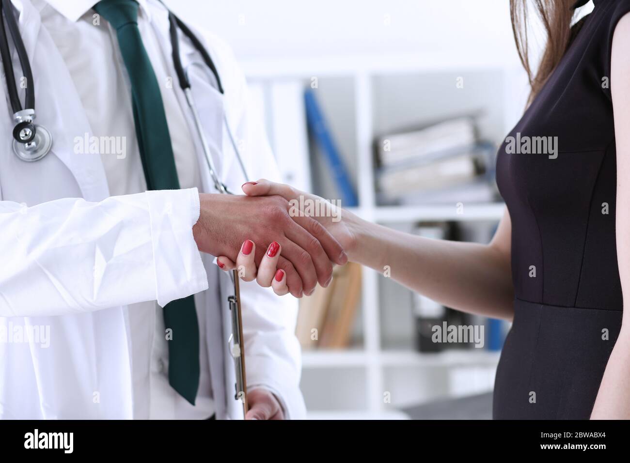 Doctor shake hand as hello with patient in office closeup Stock Photo ...