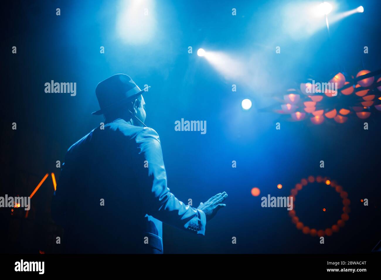 Dark-skinned singer in a suit and hat on a stage illuminated Stock ...