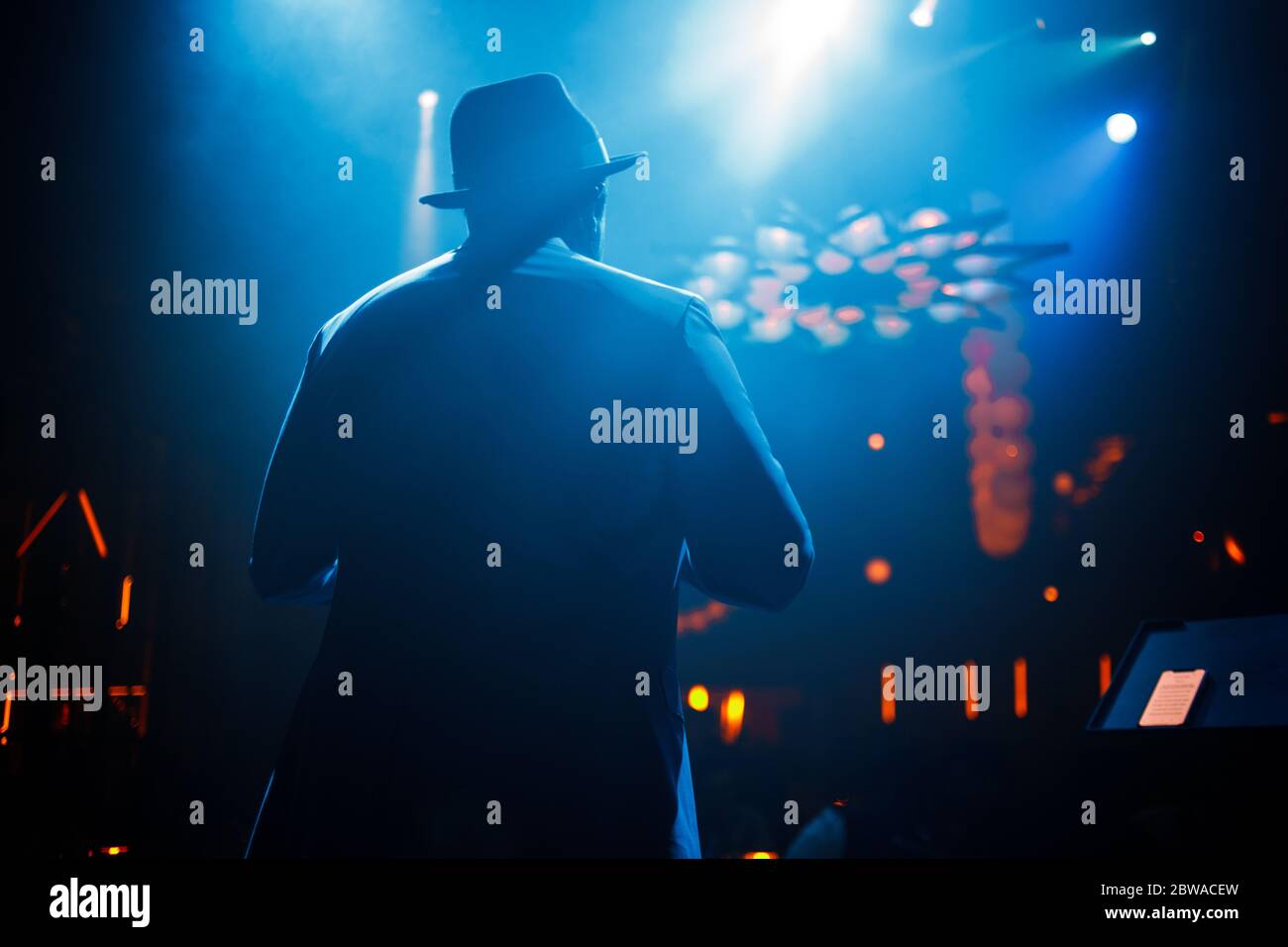 Dark-skinned singer in a suit and hat on a stage illuminated Stock ...