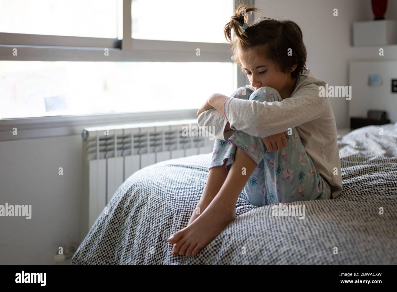Nine-year-old girl sitting in bed bored by confinement Stock Photo - Alamy