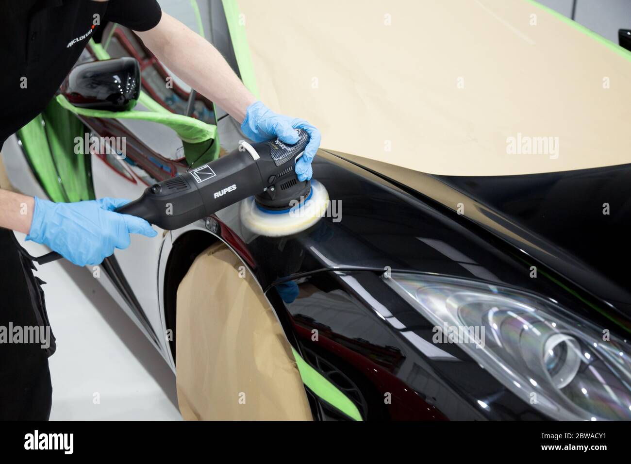 Detailer using a rotary machine on a sports car panel Stock Photo - Alamy