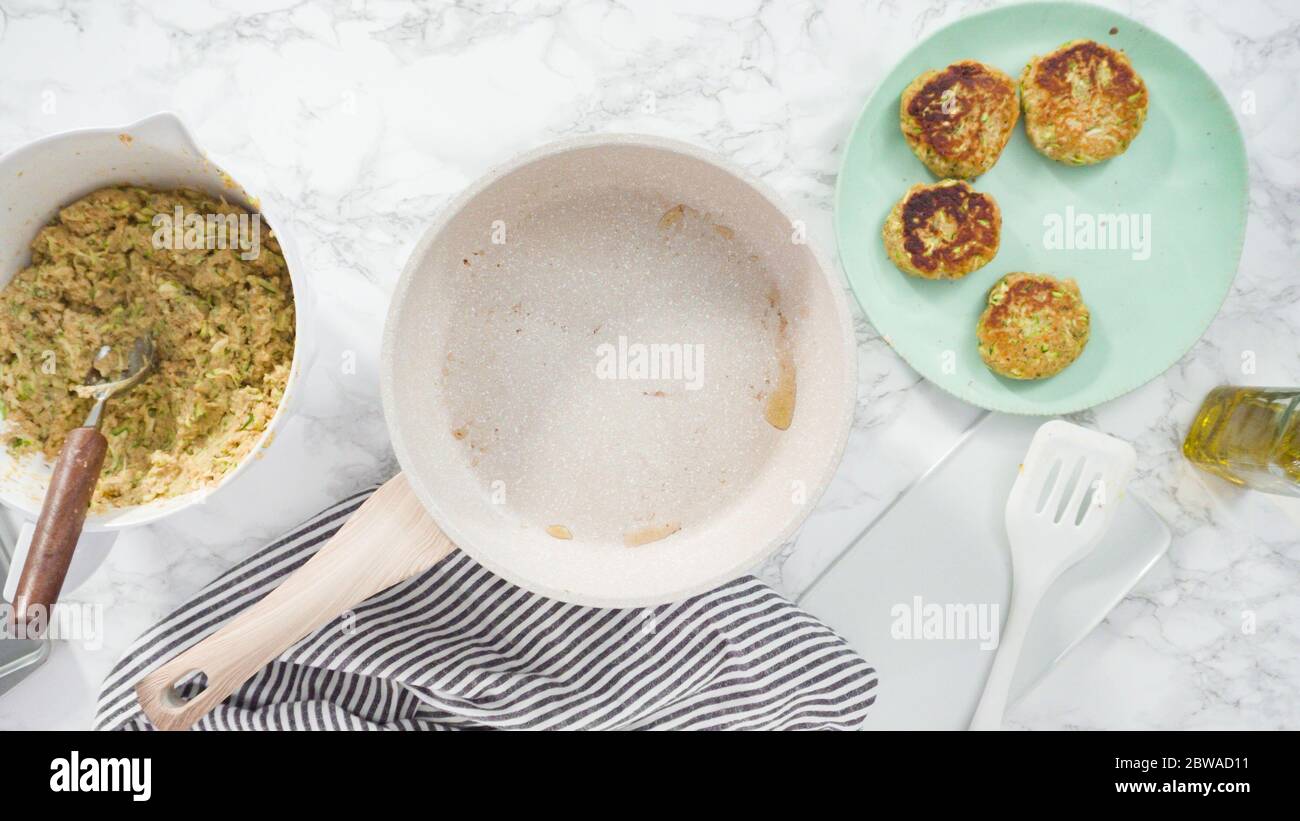 Flat lay. Step by step. Frying zucchini cakes in olive oil on a small ...