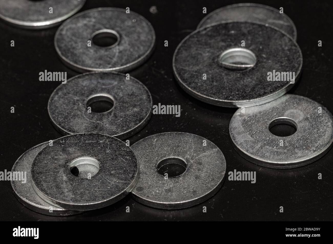black and white image of some metal washers of various sizes scattered ...