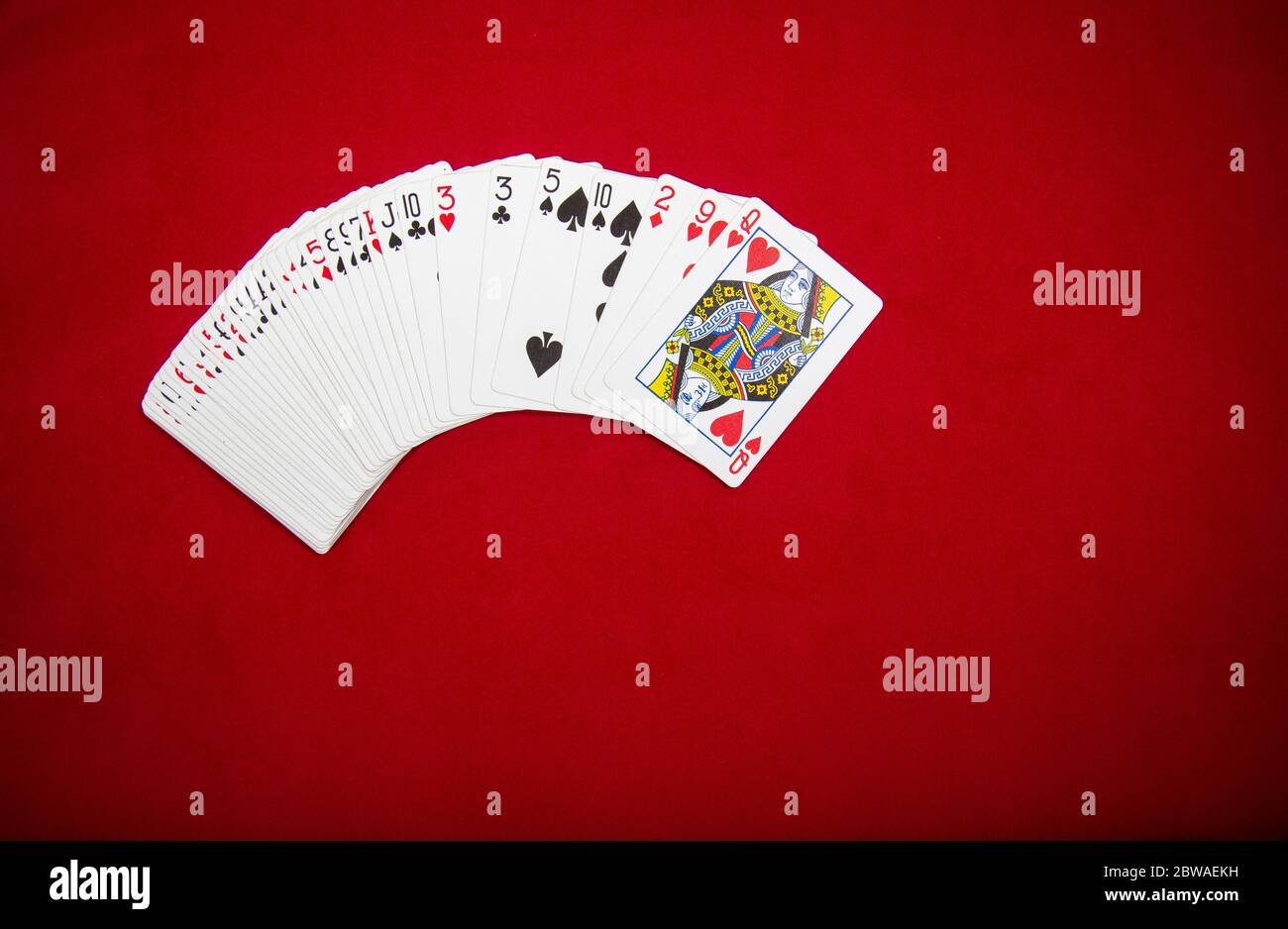 Deck of playing cards on red color velvet background. Top view with ...