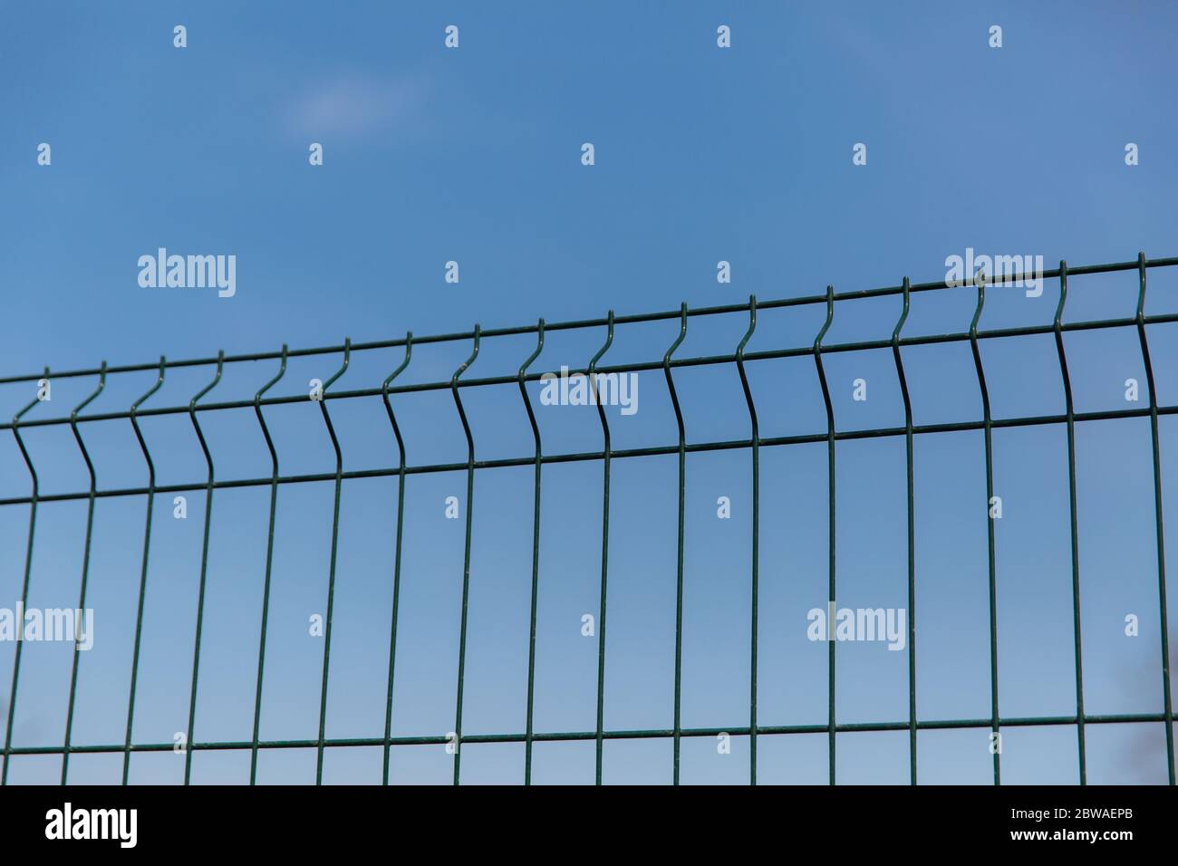 Steel grill fence with wire against the blue sky Stock Photo - Alamy