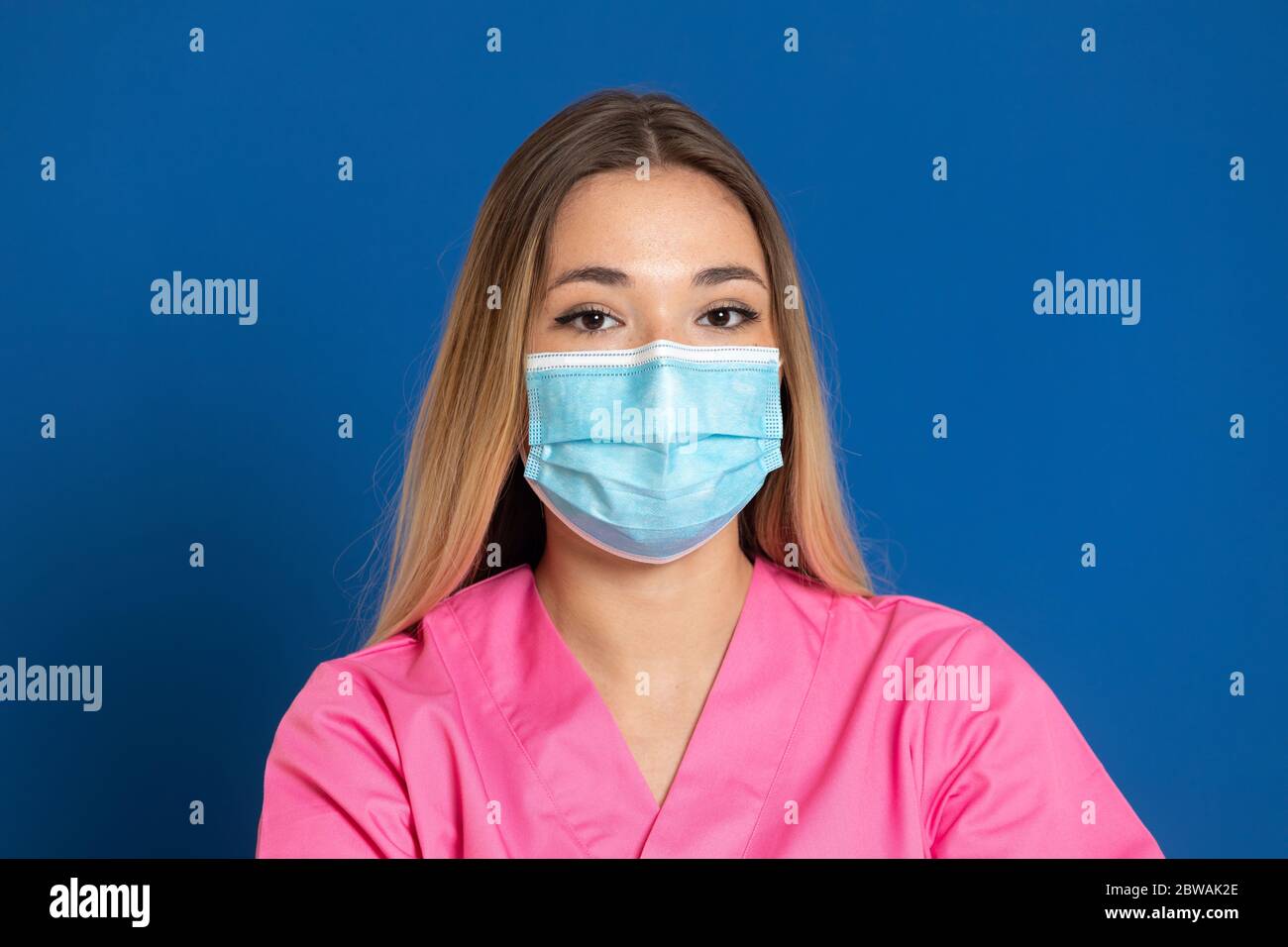 Young doctor wearing a mask face and a pink uniform on a blue ...