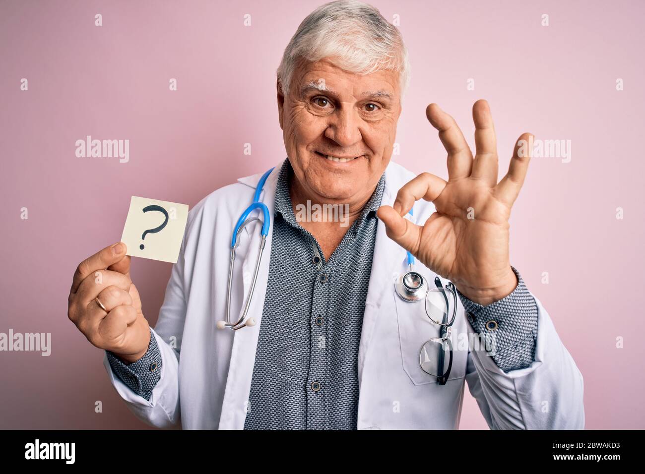 Senior handsome hoary doctor man wearing stethoscope holding reminder ...