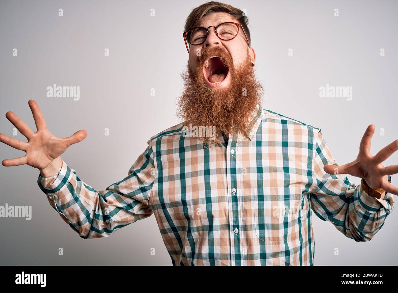 Handsome Irish redhead man with beard wearing glasses and hipster shirt ...