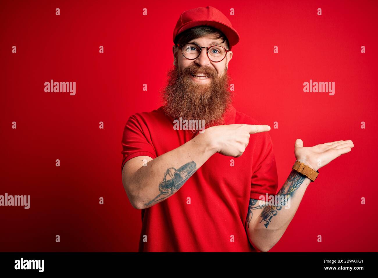 Young handsome delivery man wearing glasses and red cap over isolated ...