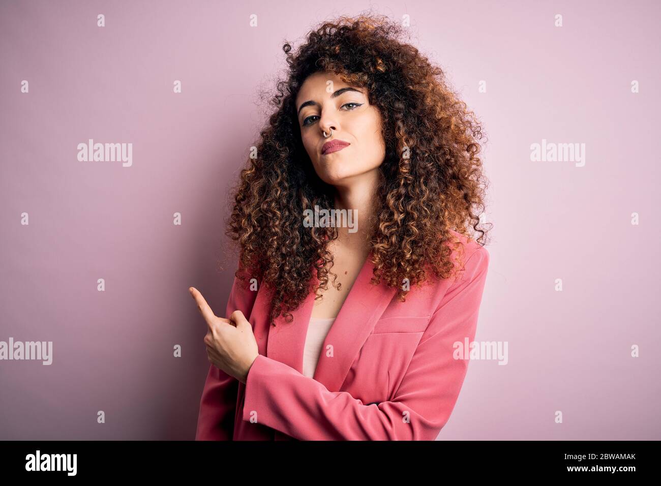 Young beautiful businesswoman with curly hair and piercing wearing ...
