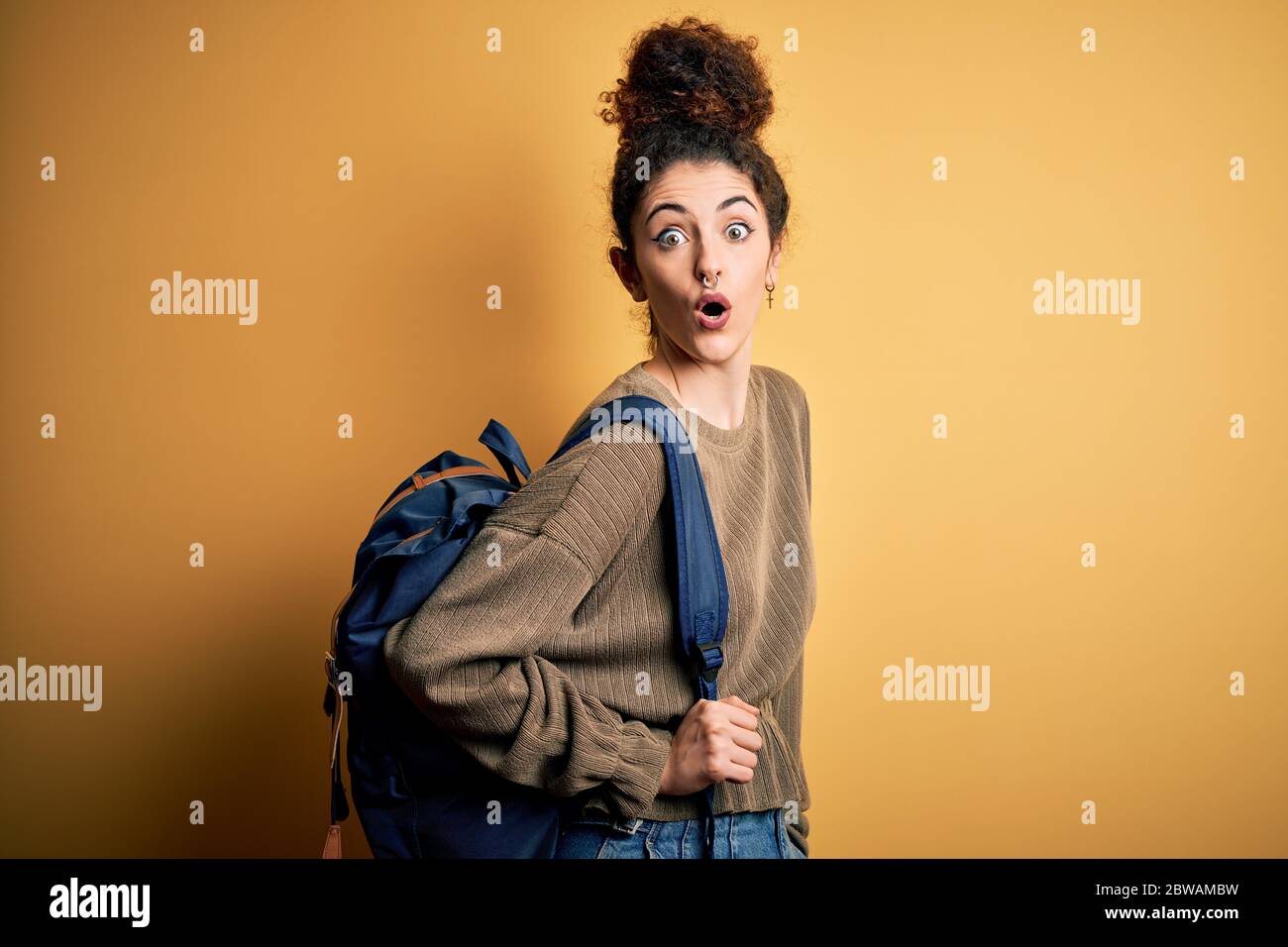 Young beautiful student woman with curly hair and piercing wearing ...