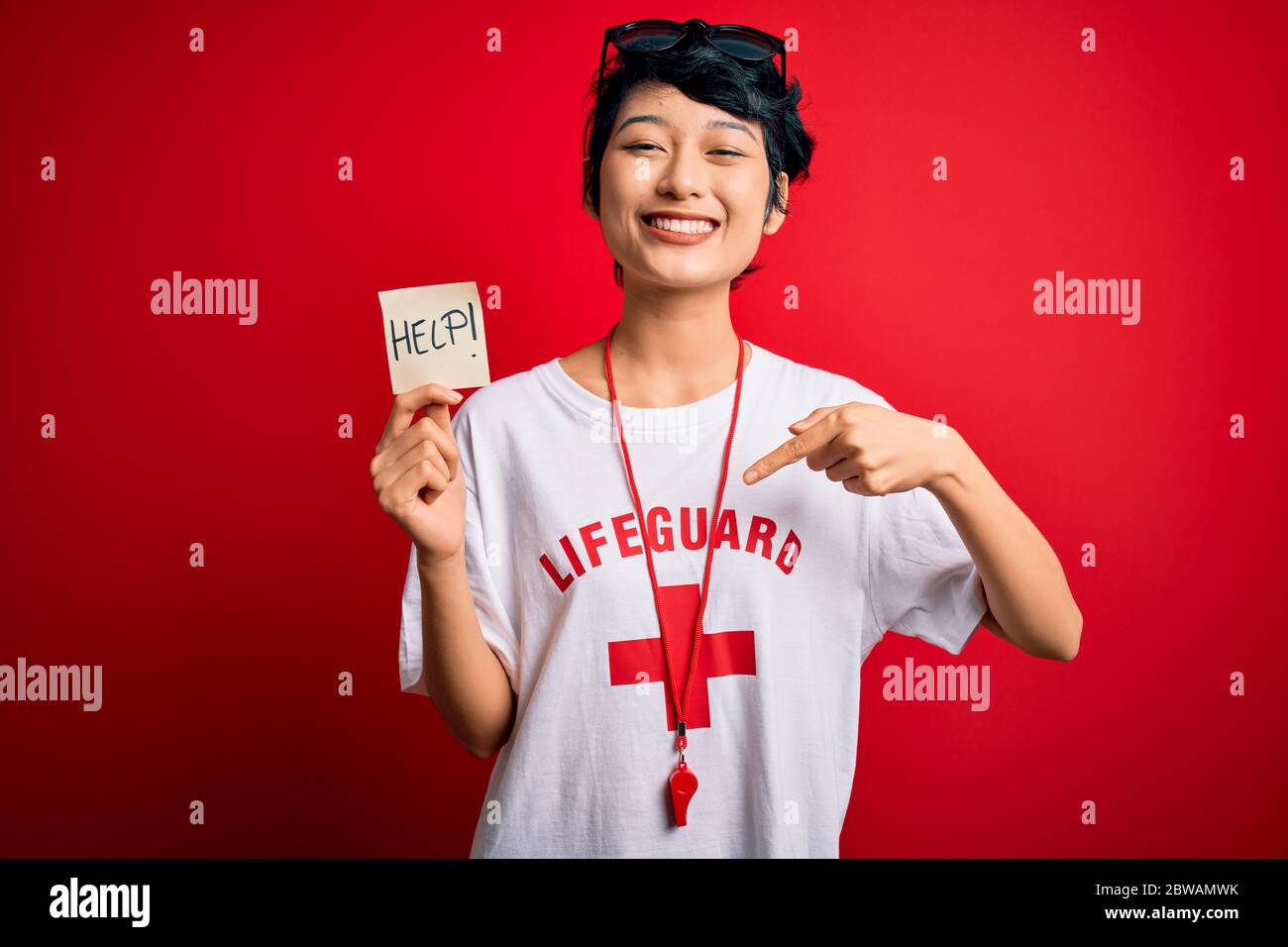 Young beautiful asian lifeguard girl using whistle holding reminder ...