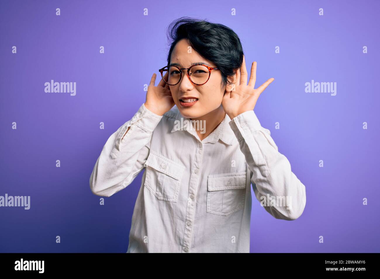 Young beautiful asian girl wearing casual shirt and glasses standing ...
