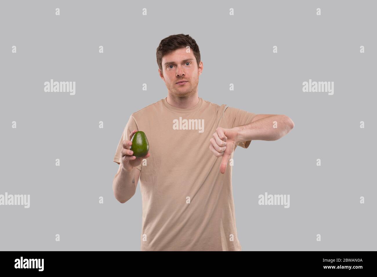 Man Showing Avocado and Thumb Down Isolated. No Avocado, Stop Avocado ...