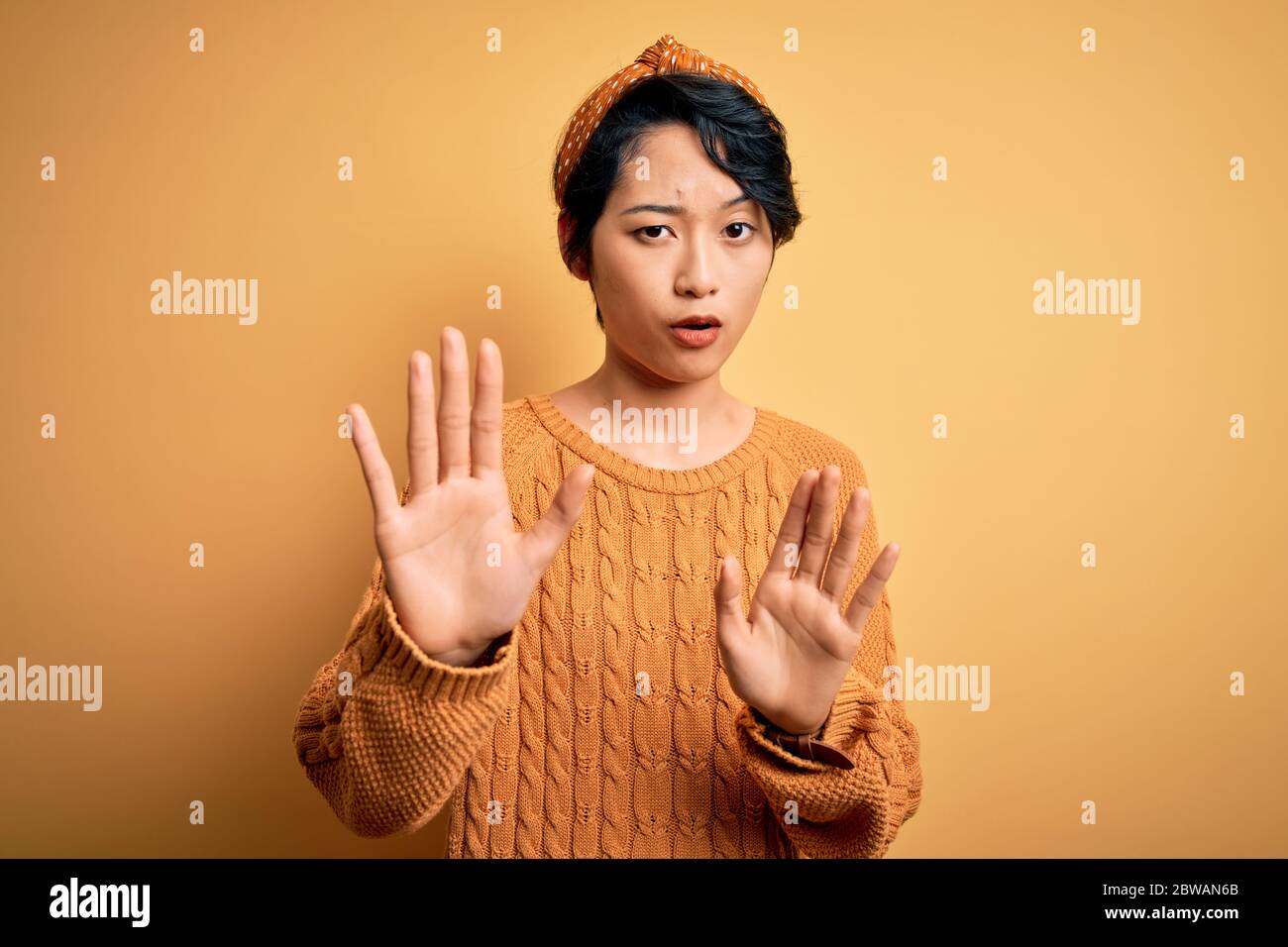 Young beautiful asian girl wearing casual sweater and diadem standing ...