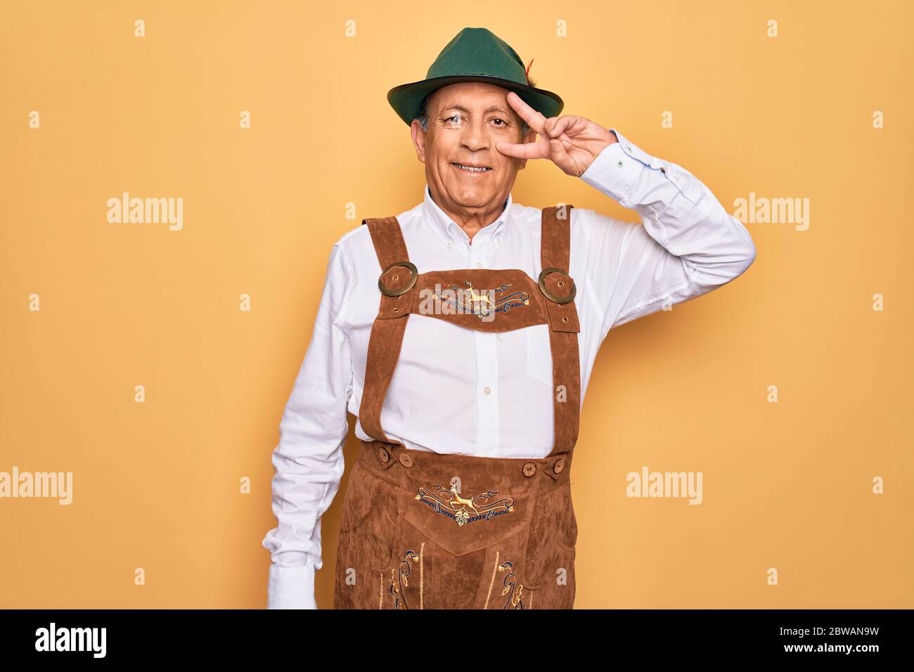 Senior grey-haired man wearing german traditional octoberfest suit over ...