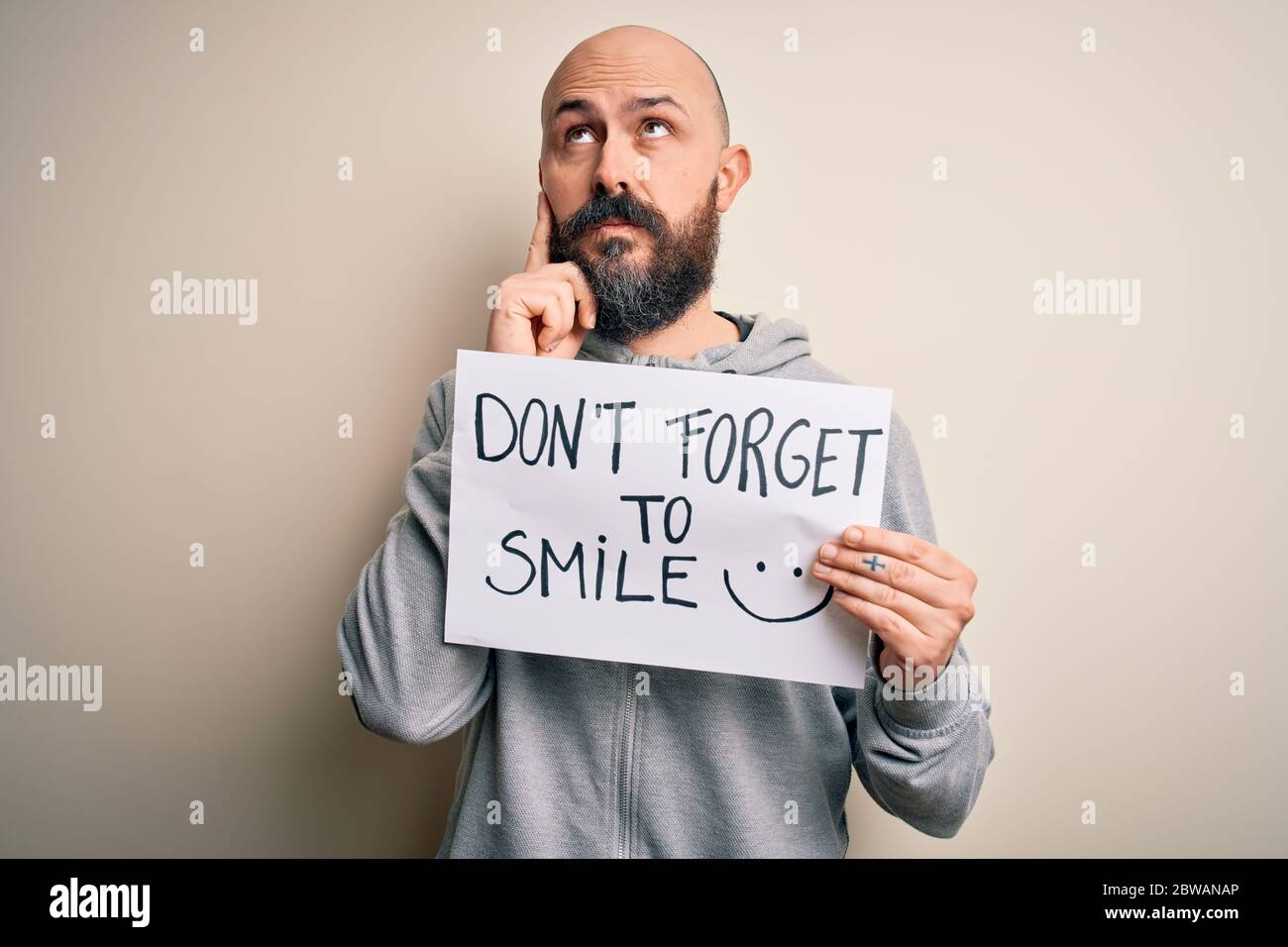 Handsome bald man with beard holding banner with funny positive message ...