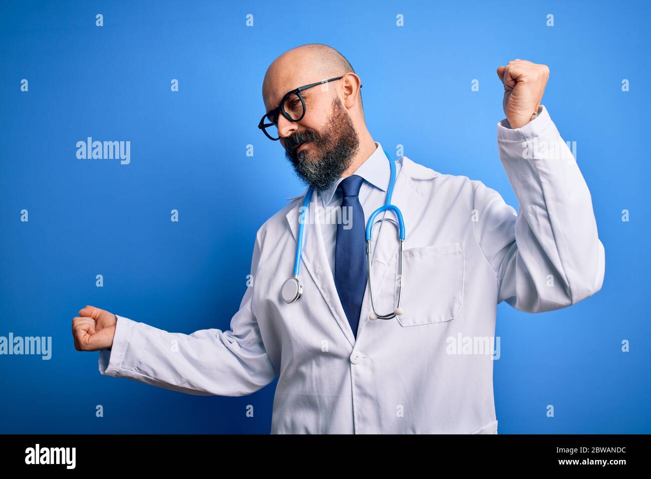 Handsome bald doctor man with beard wearing glasses and stethoscope ...