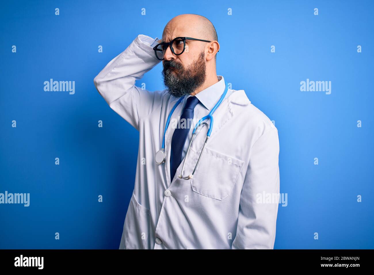Handsome bald doctor man with beard wearing glasses and stethoscope ...