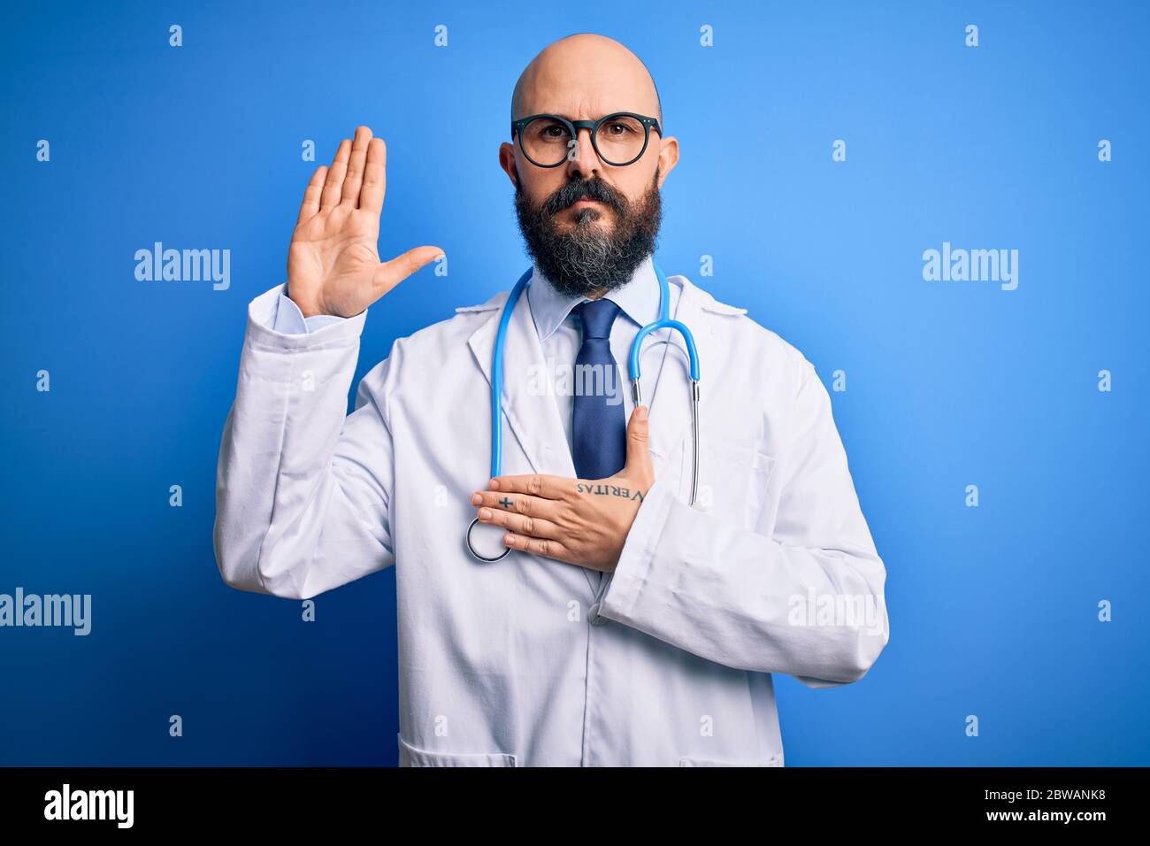 Handsome bald doctor man with beard wearing glasses and stethoscope ...