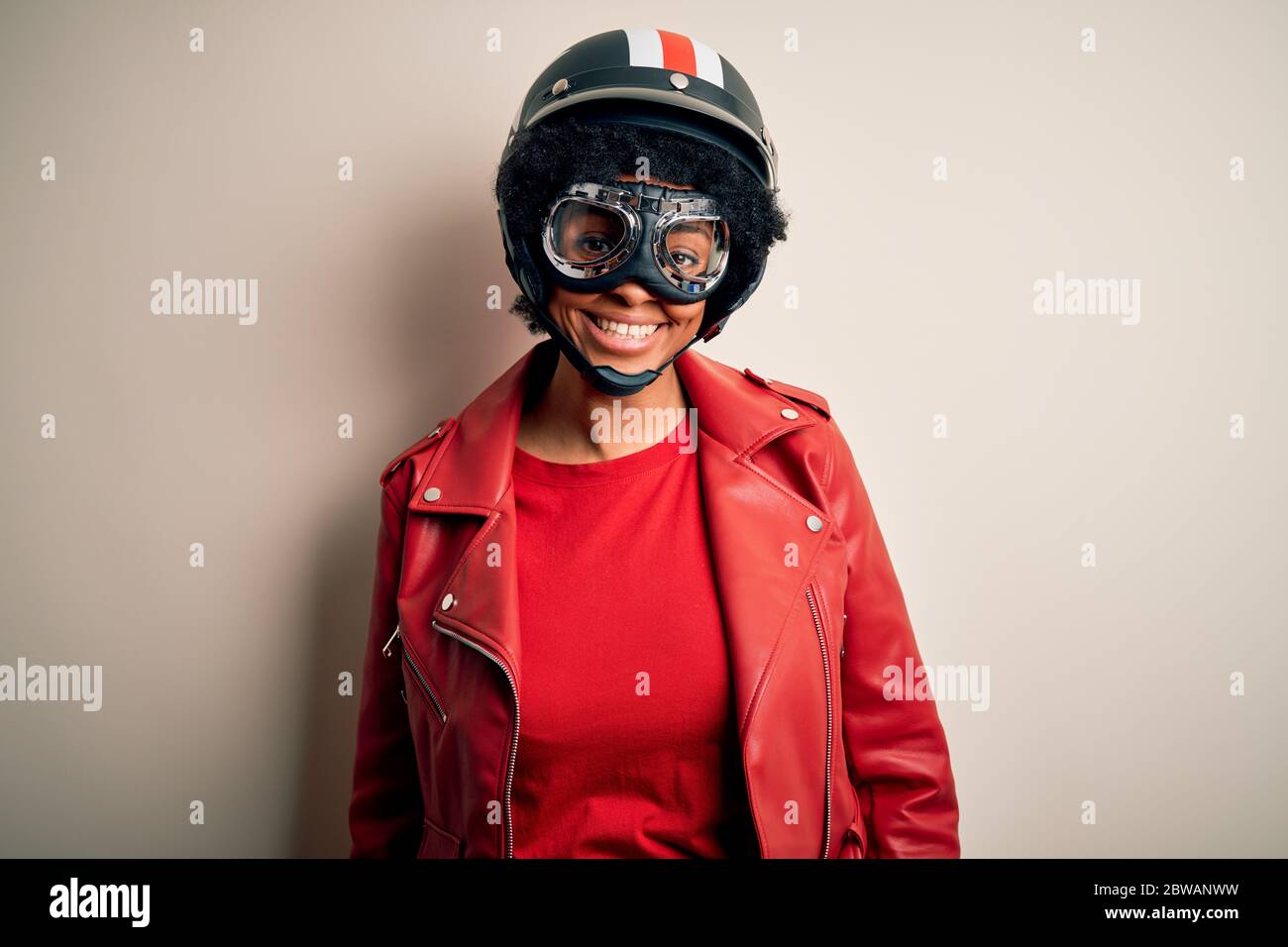 Young African American afro motorcyclist woman with curly hair wearing ...