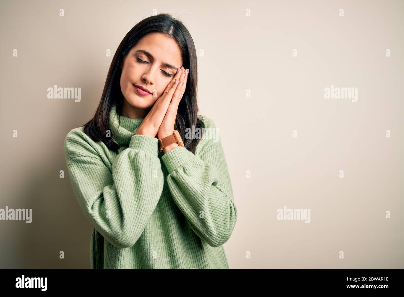 Young brunette woman with blue eyes wearing turtleneck sweater over ...