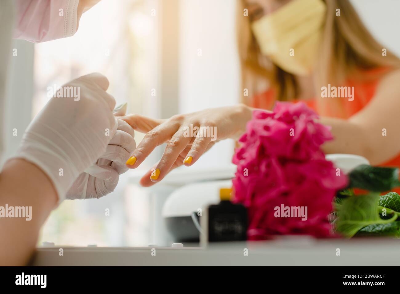 Woman with face mask during manicure in nail salon Stock Photo - Alamy