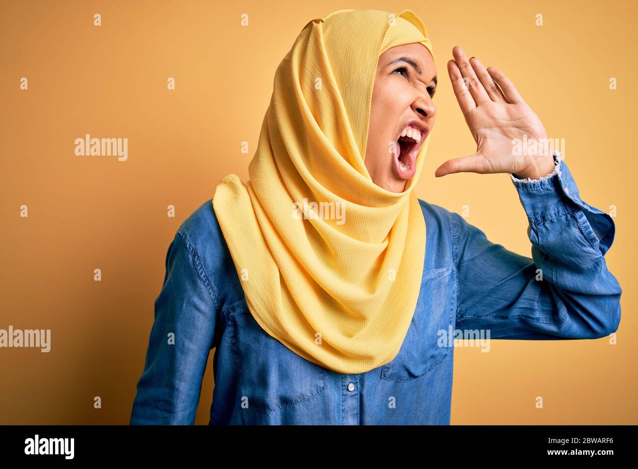 Young beautiful woman with curly hair wearing arab traditional hijab ...