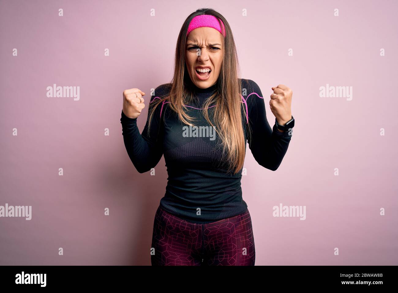 Young blonde fitness woman wearing sport workout clothes over isolated ...