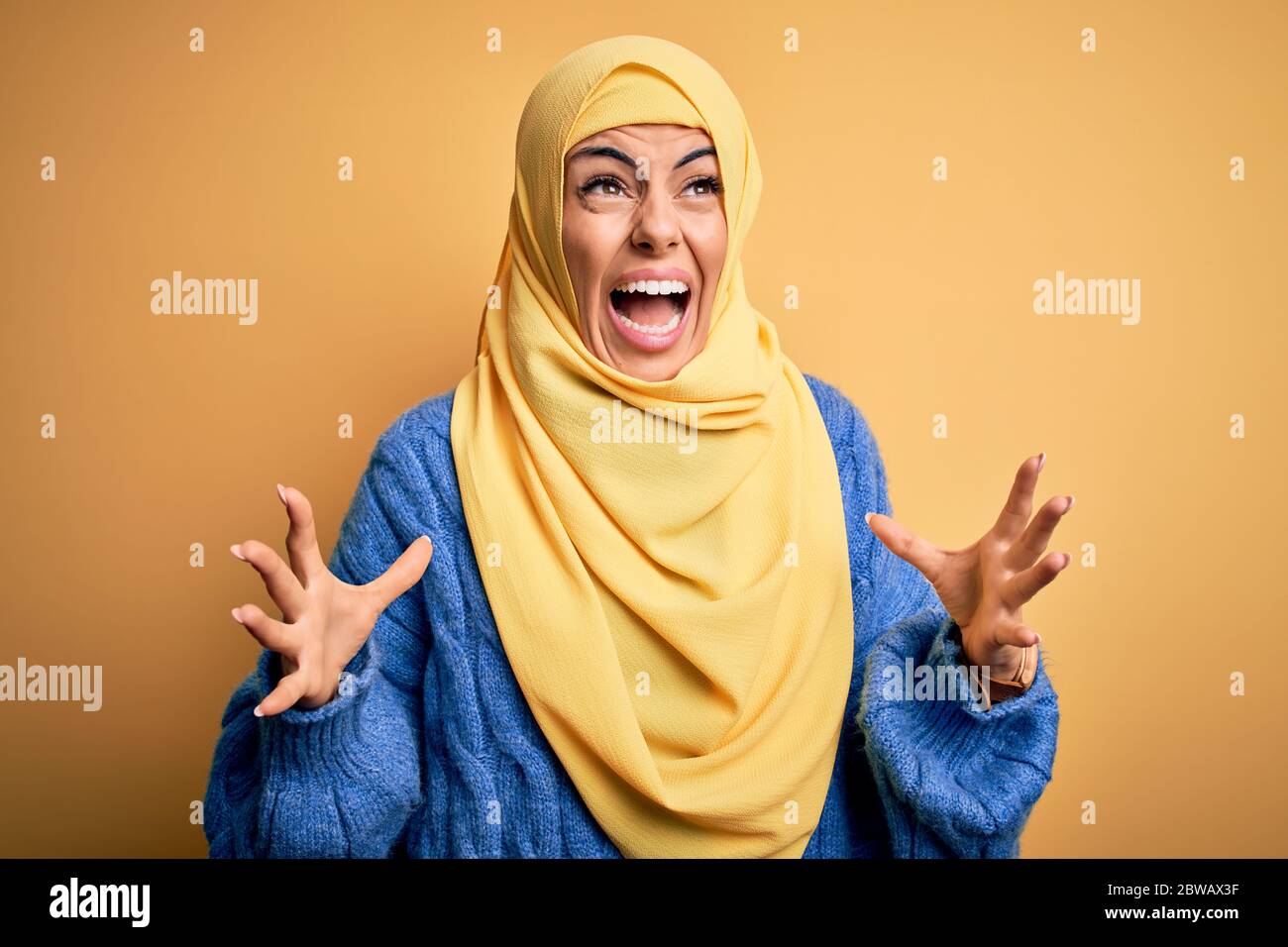 Young beautiful brunette muslim woman wearing arab hijab over isolated ...
