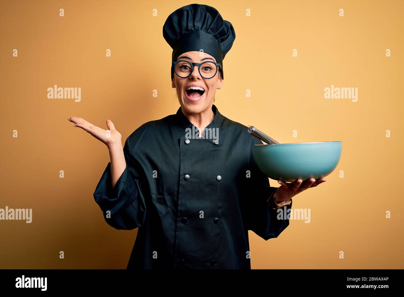 Young beautiful brunette chef woman wearing cooker uniform and hat ...