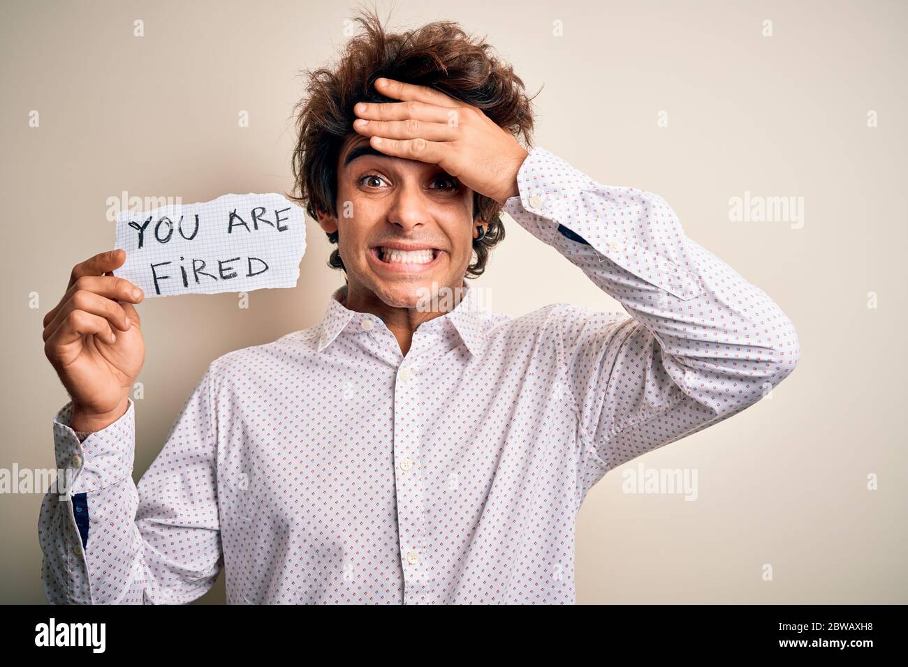 Young handsome man holding paper with message standing over isolated ...