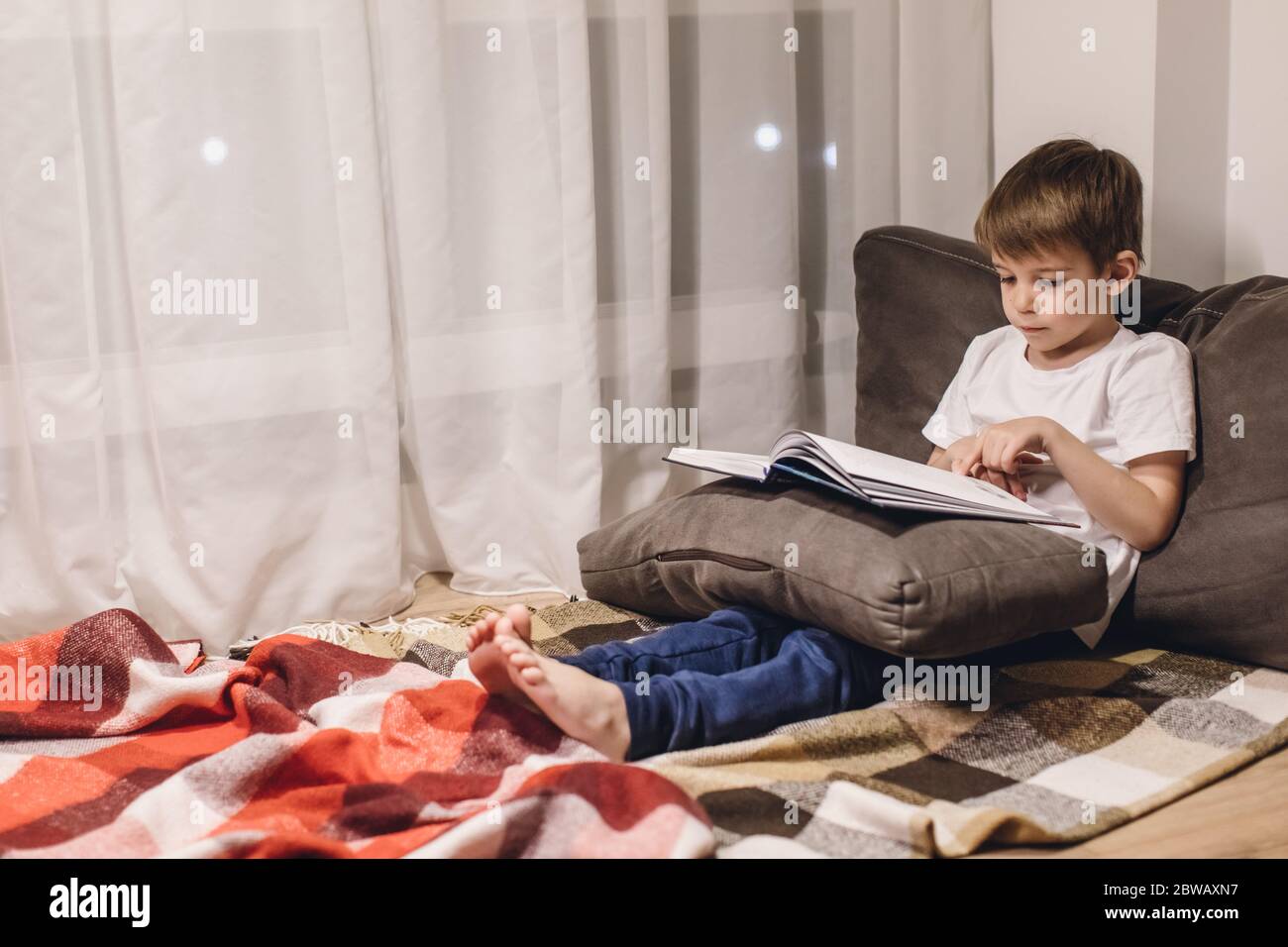 Little boy Reading a Book in a Cozy Room Stock Photo - Alamy