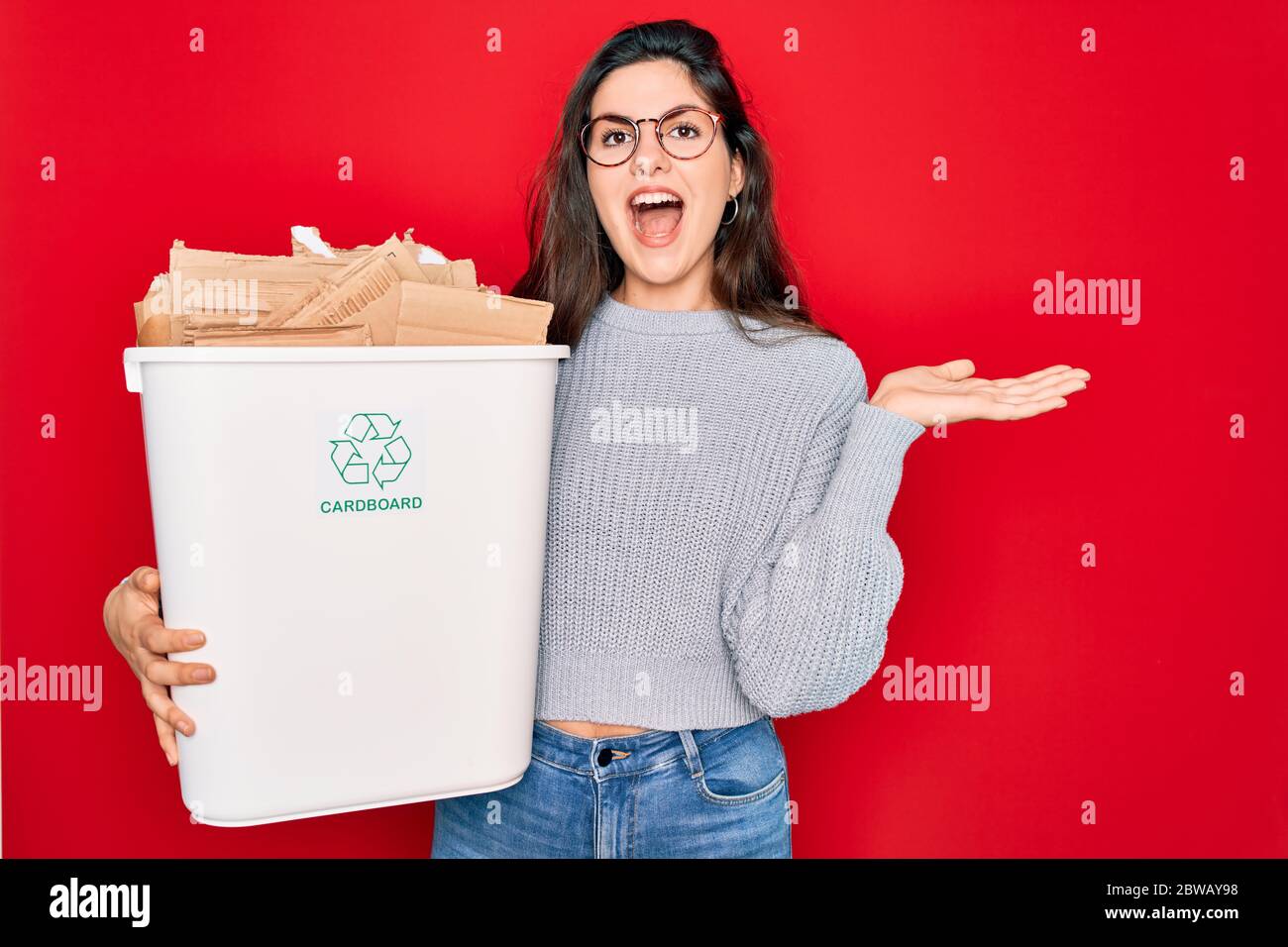 Young beautiful woman holding recycle cardboard containter recycling ...