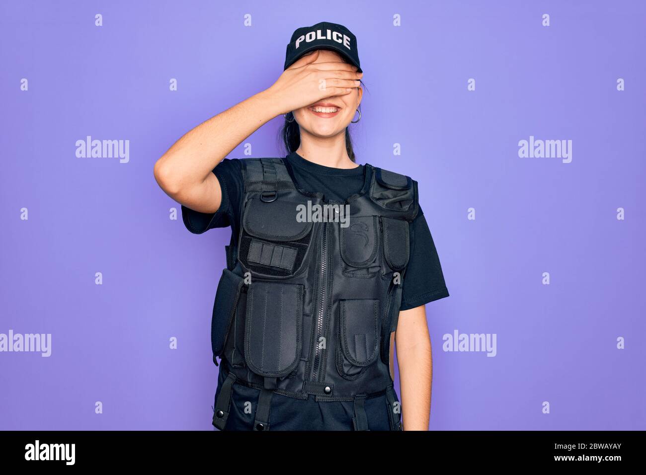 Young police woman wearing security bulletproof vest uniform over ...